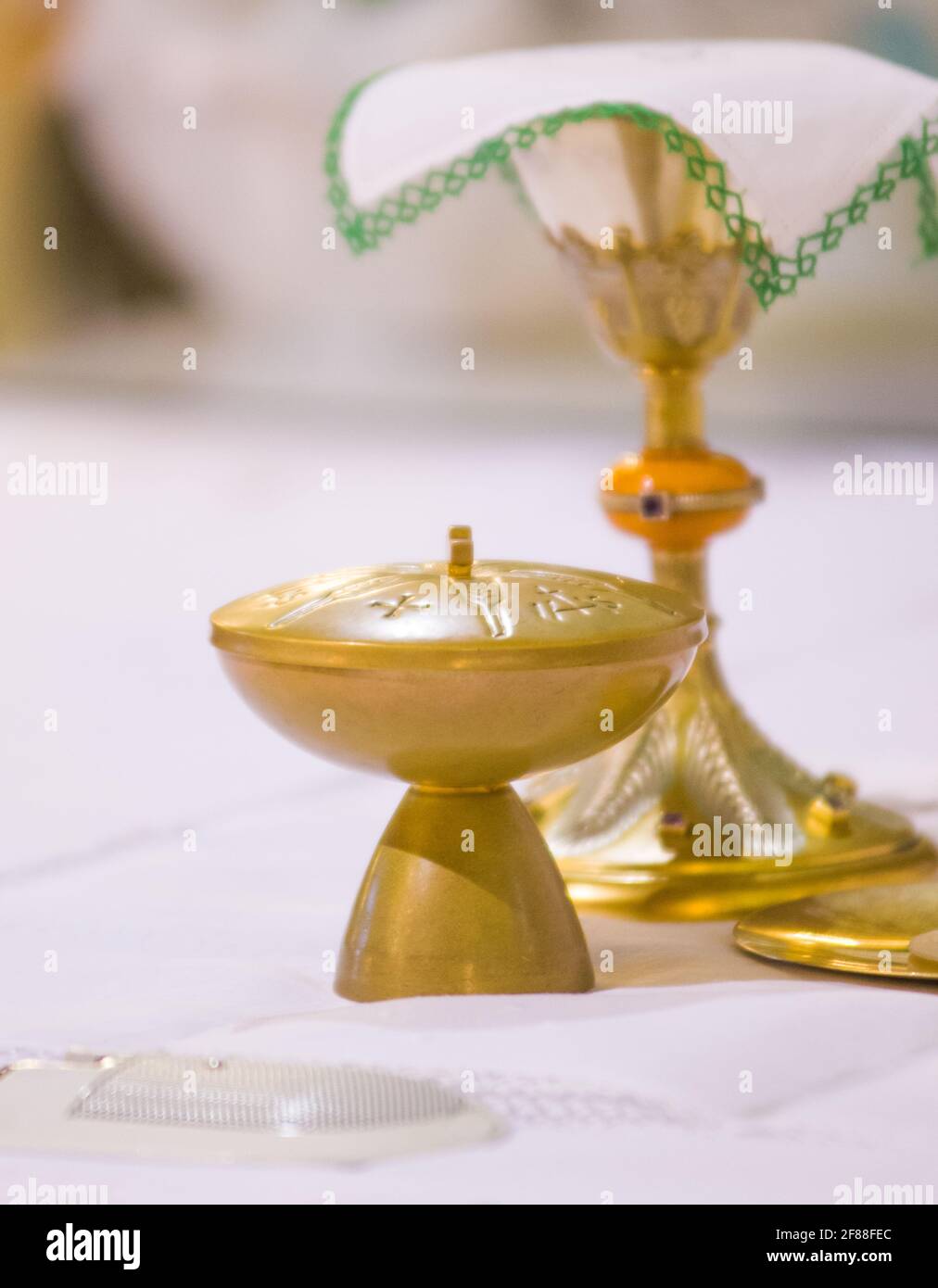 hands of the priest raise the cup containing the blood of Christ, the ...