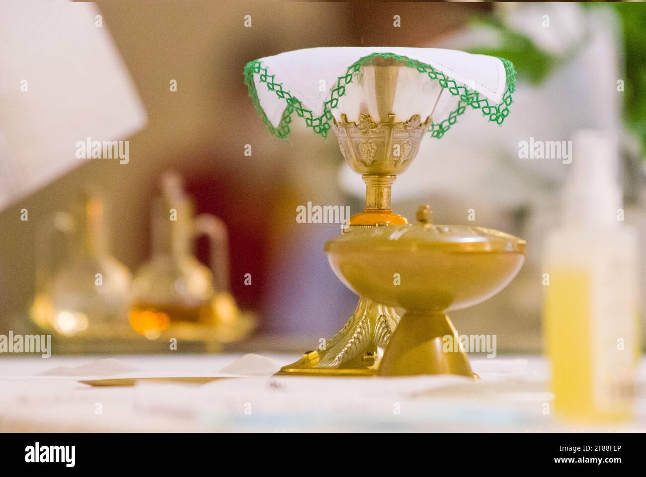 hands of the priest raise the cup containing the blood of Christ, the ...