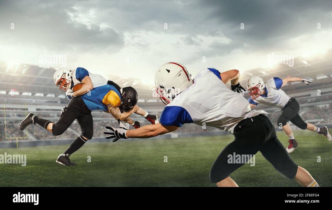 American football players in fight for goal at stadium in flashlights ...