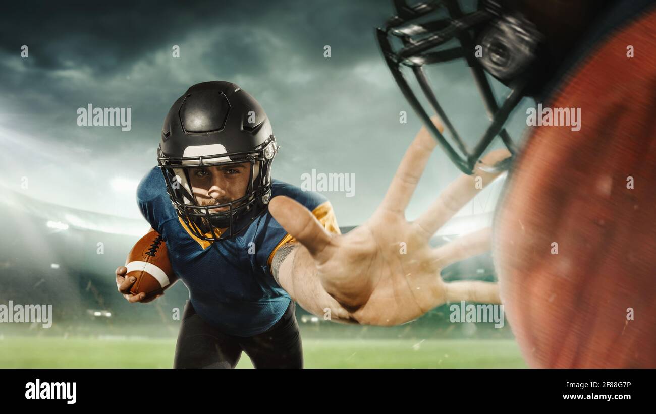 American football players in fight for goal at stadium in flashlights ...