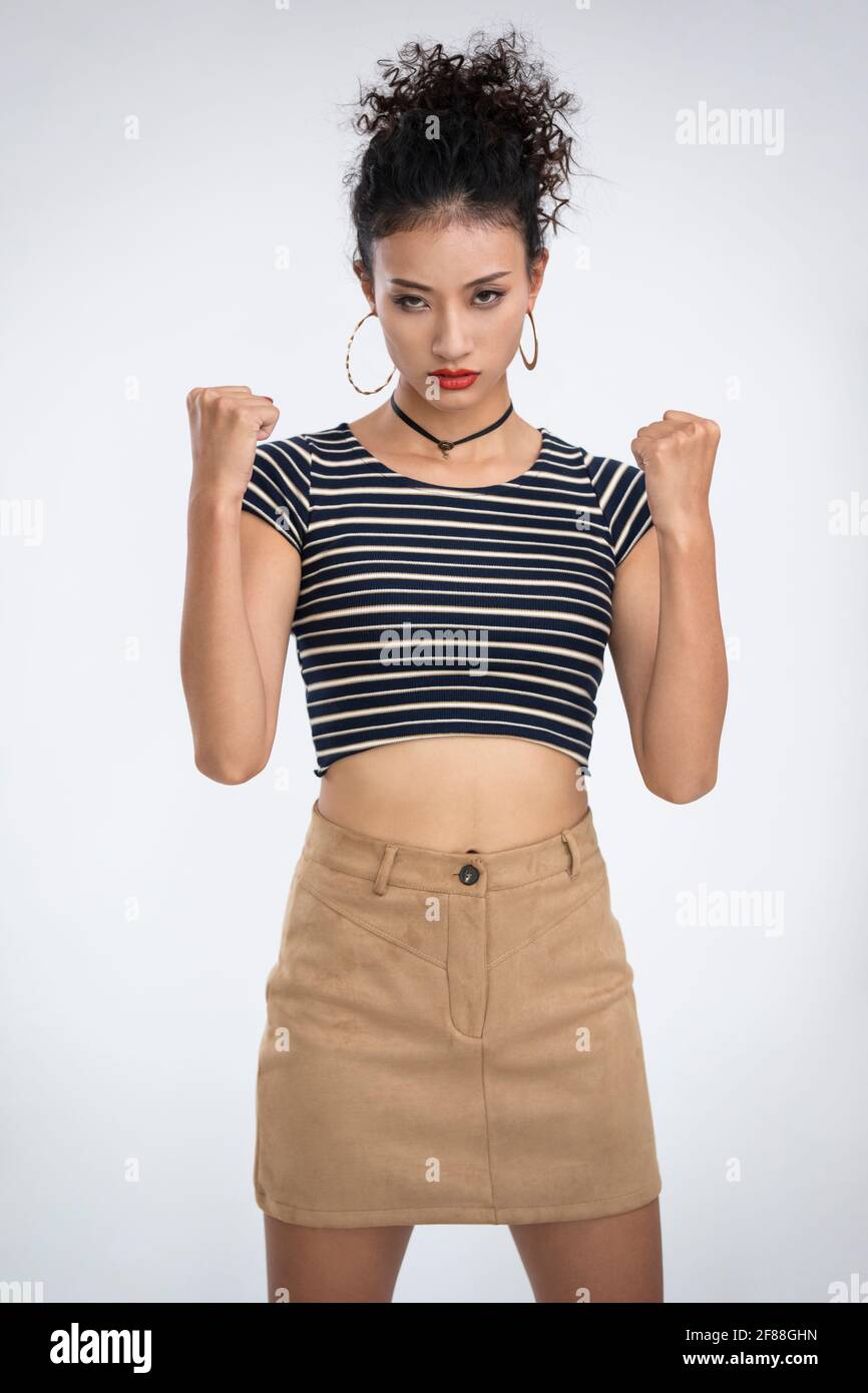 Cool young woman shaking fist Stock Photo - Alamy