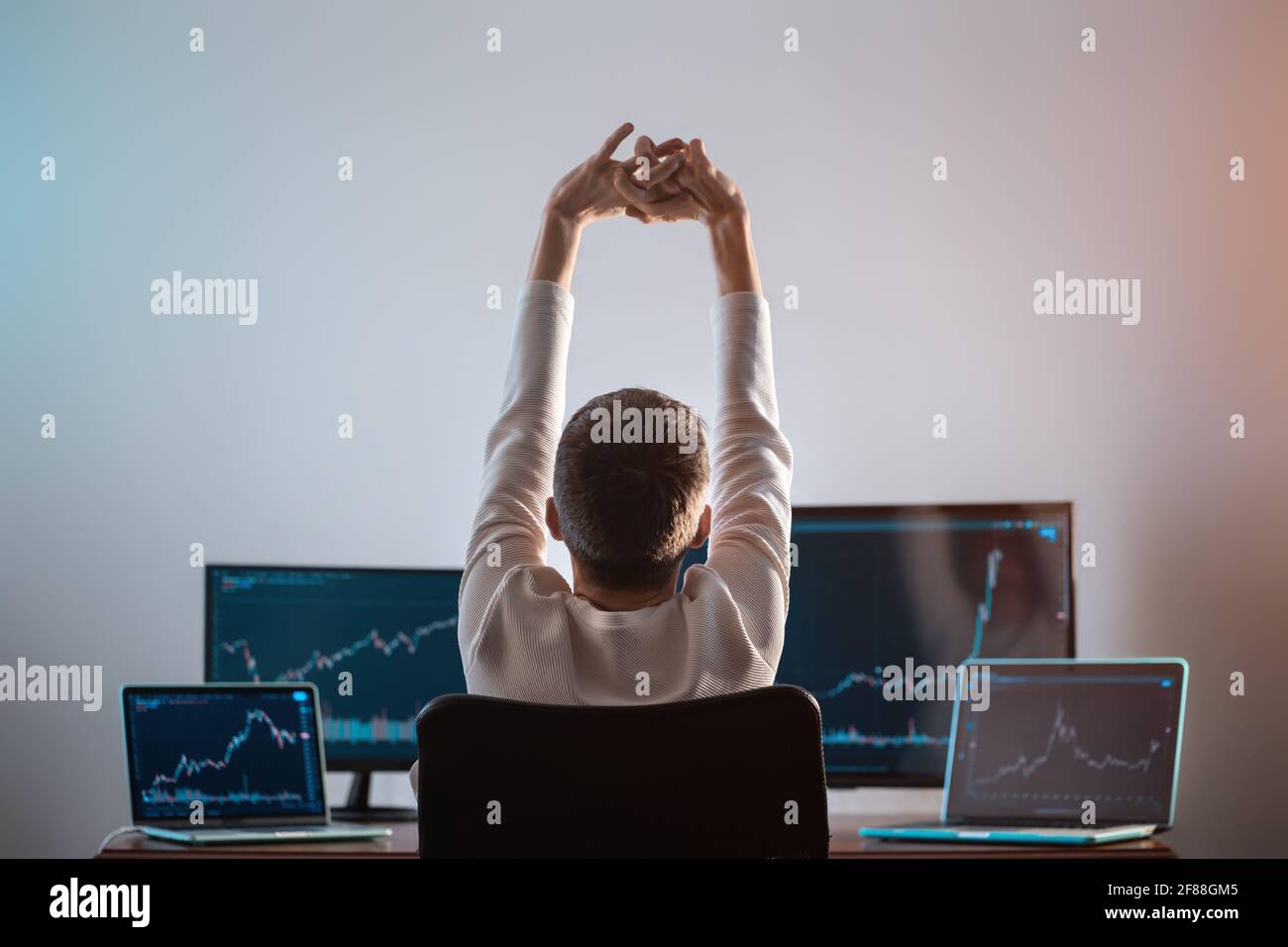 relaxed successful male trader resting with stock exchange graph or ...