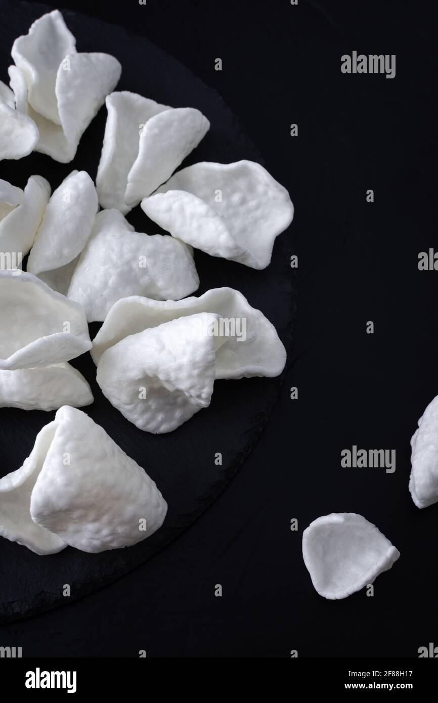 White crispy potato chips scattered on black background Stock Photo - Alamy