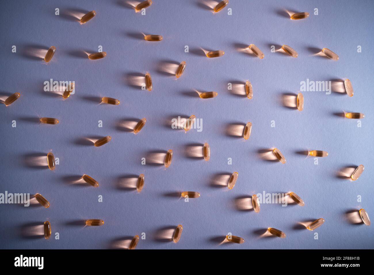 healthy golden fish oil capsules omega 3 vitamins on purple background ...