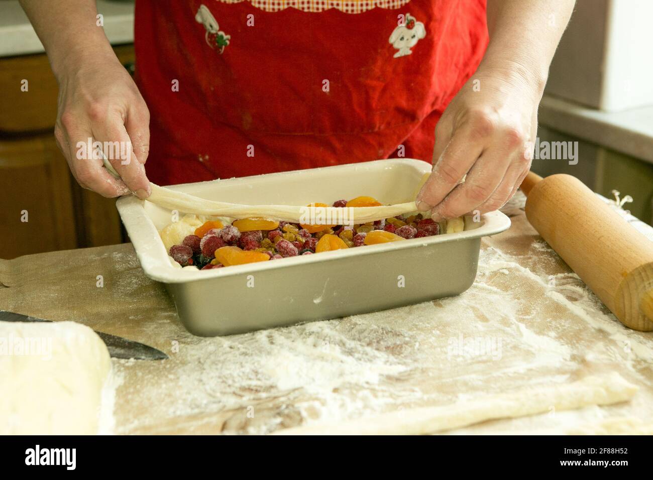 Mom's pies. Mom covers the pie with strips of dough. Female hands ...