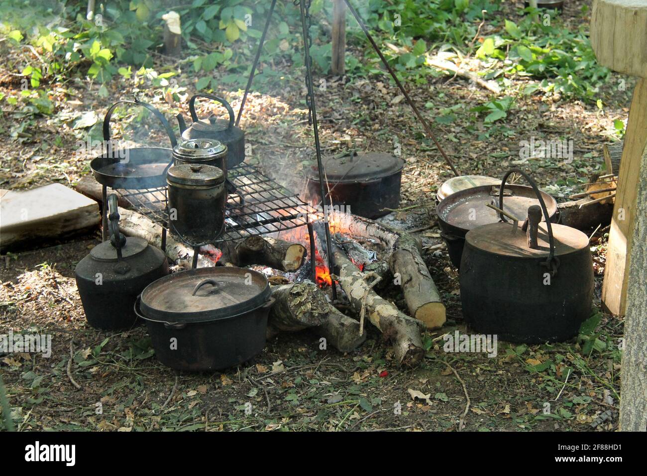 A Collection of Pots and Pans Around a Wood Fire Stock Photo - Alamy
