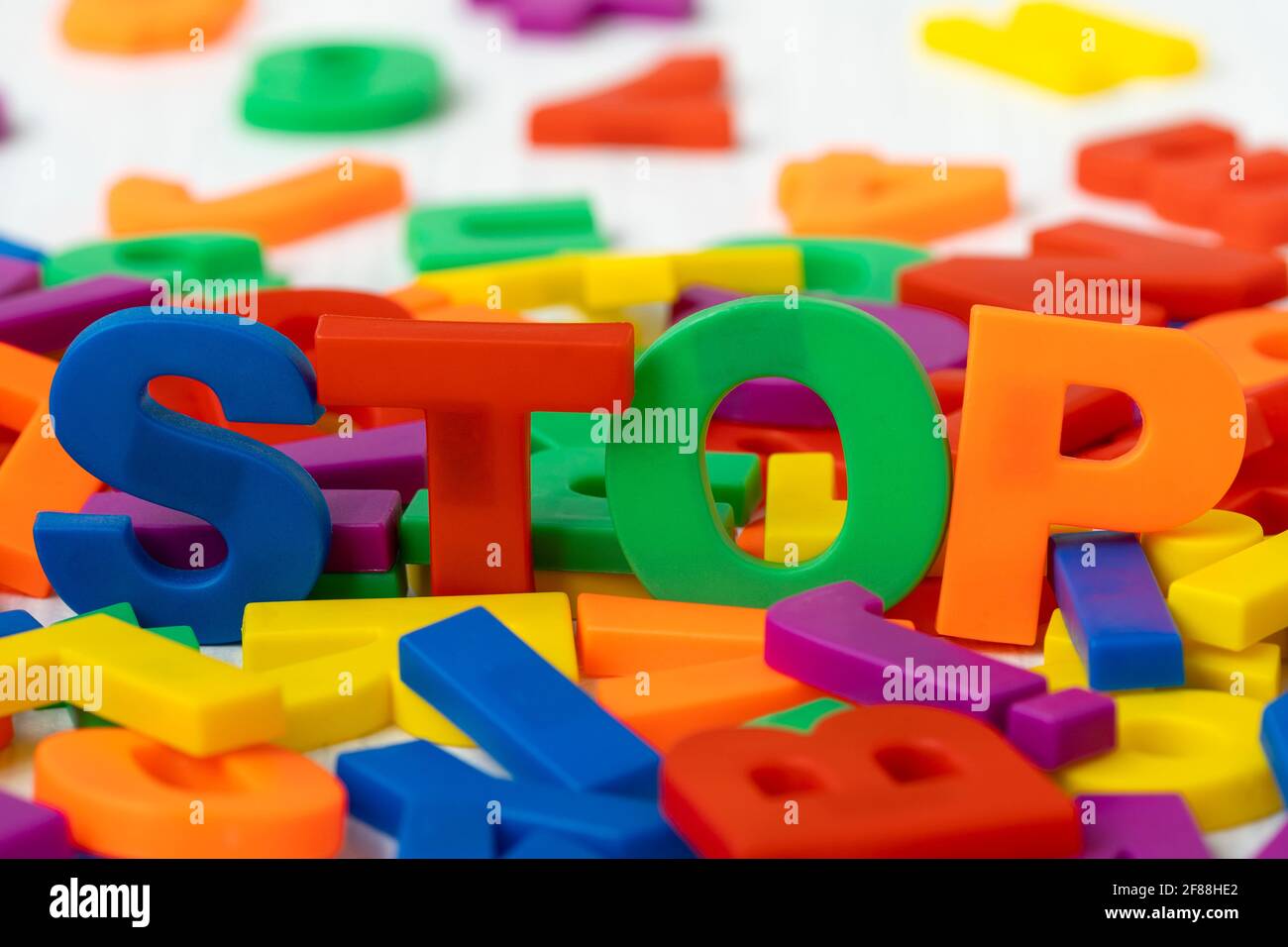 The inscription STOP from plastic colored letters Stock Photo - Alamy