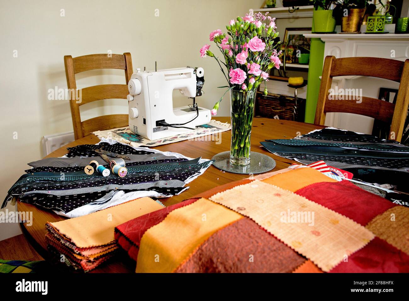 A dining room table laid out with a sewing machine and materials ...
