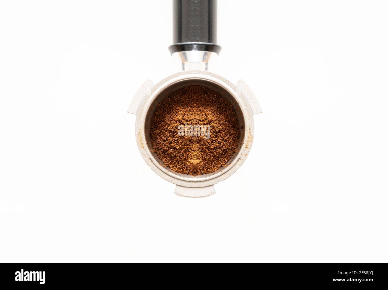 Portafilter with ground coffee inside on white background in studio ...