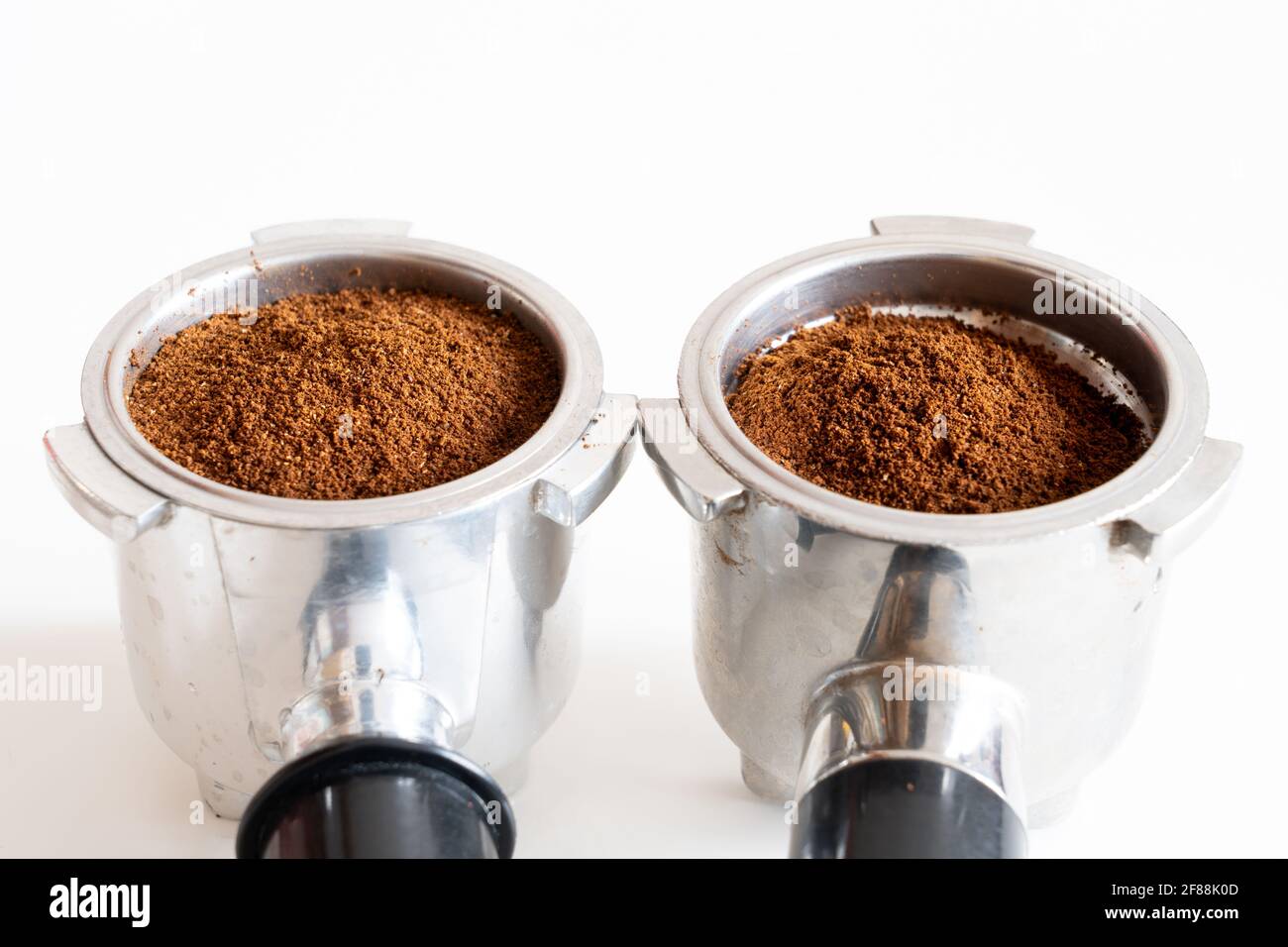 Portafilter with ground coffee inside on white background in studio ...
