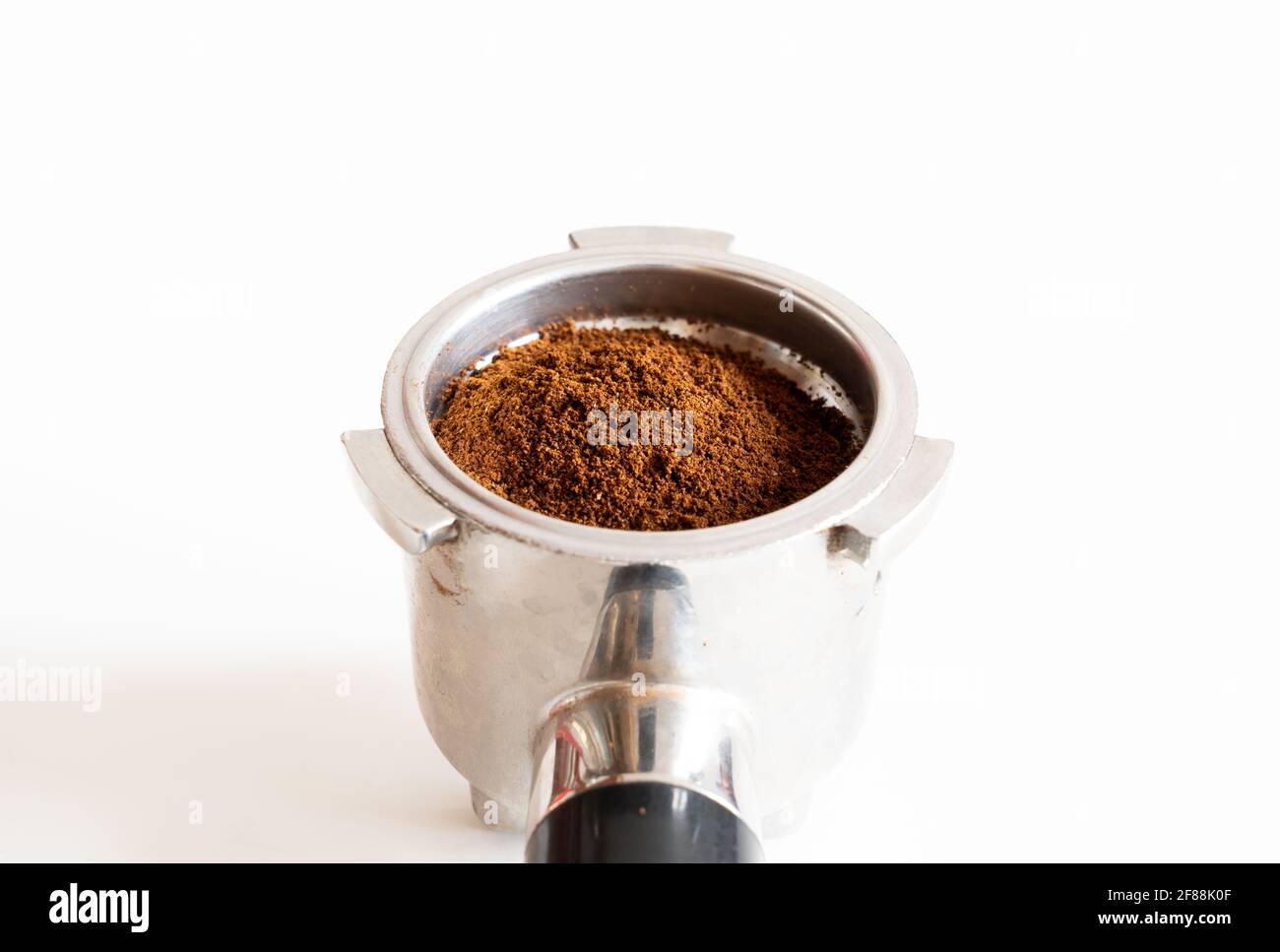 Portafilter with ground coffee inside on white background in studio ...