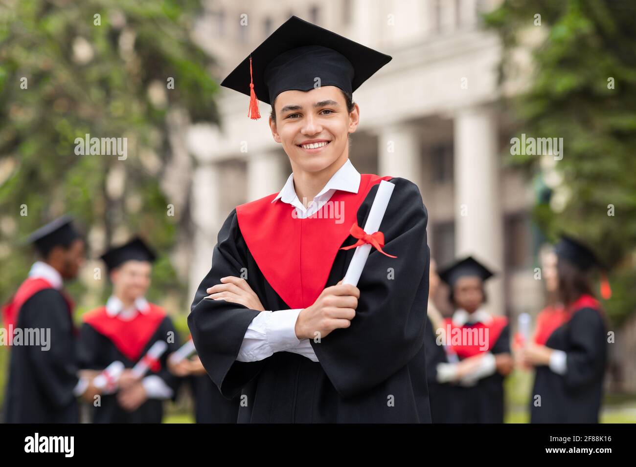 Cheerful guy in graduation costume with diploma Stock Photo - Alamy