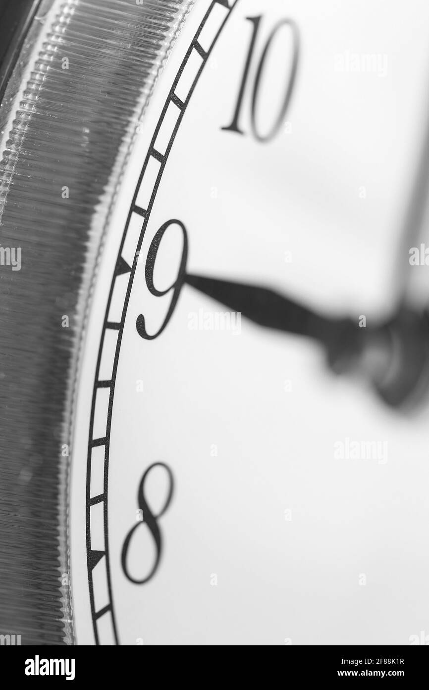 Clock hand pointing nine o'clock on white clock face of Twin bell ...