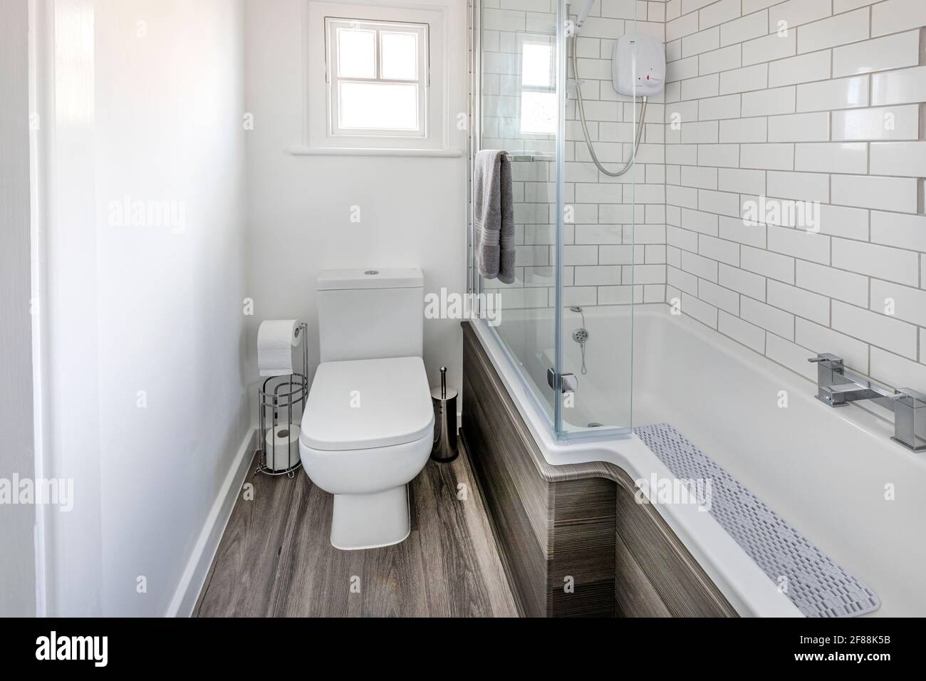 A modern bathroom with an over bath shower Stock Photo - Alamy