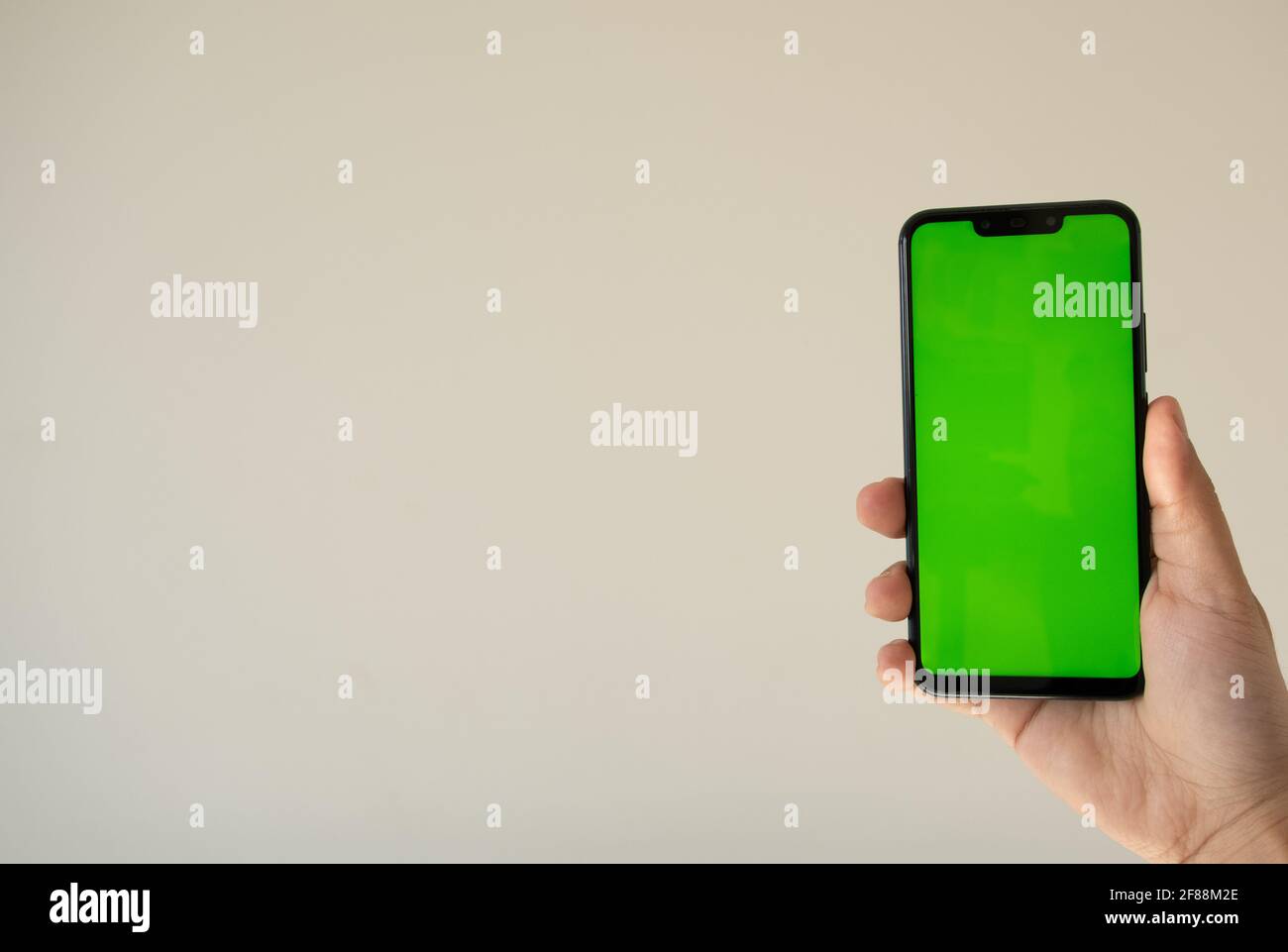 human holding mobile phone with notched and green screen in hand Stock ...