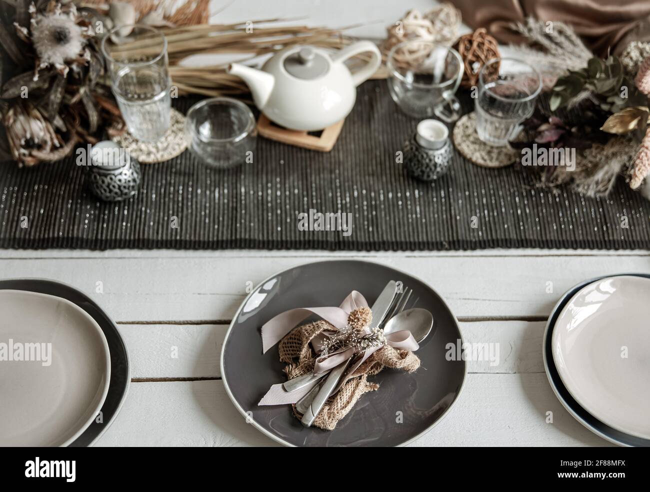 Stylish crockery and cutlery on a set table in coffee colors with ...