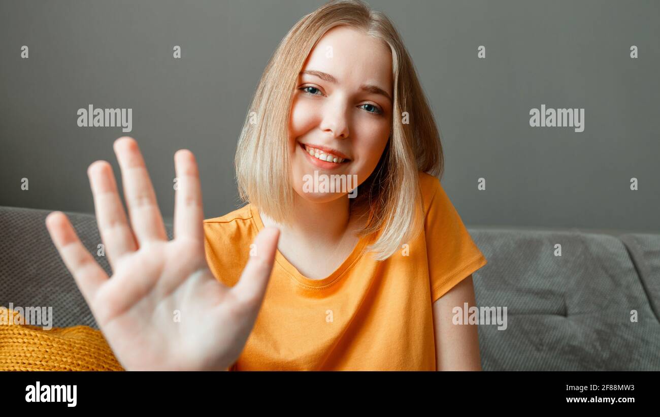 Happy woman portrait wave by hand greeting web camera view. Young ...