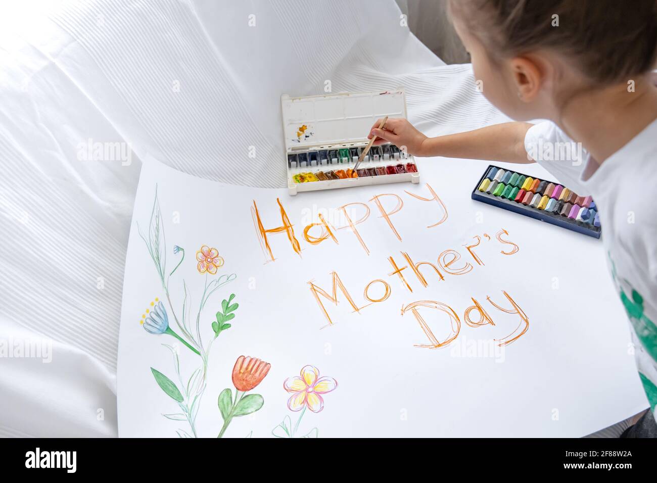 Little girl paints with paints and crayons greeting card for Mom on ...
