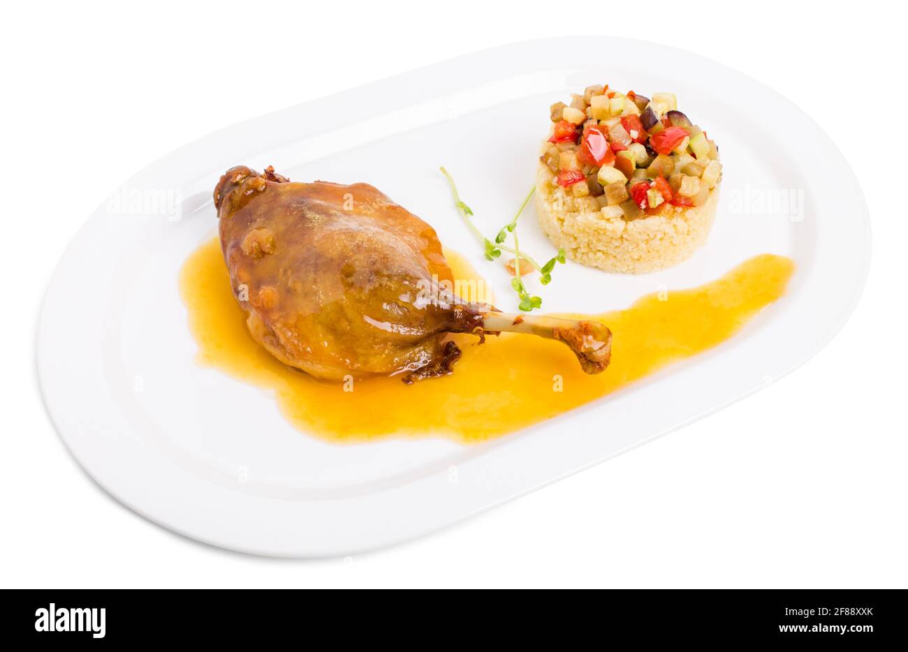 Duck leg confit with couscous and baked vegetables. Isolated on a white ...