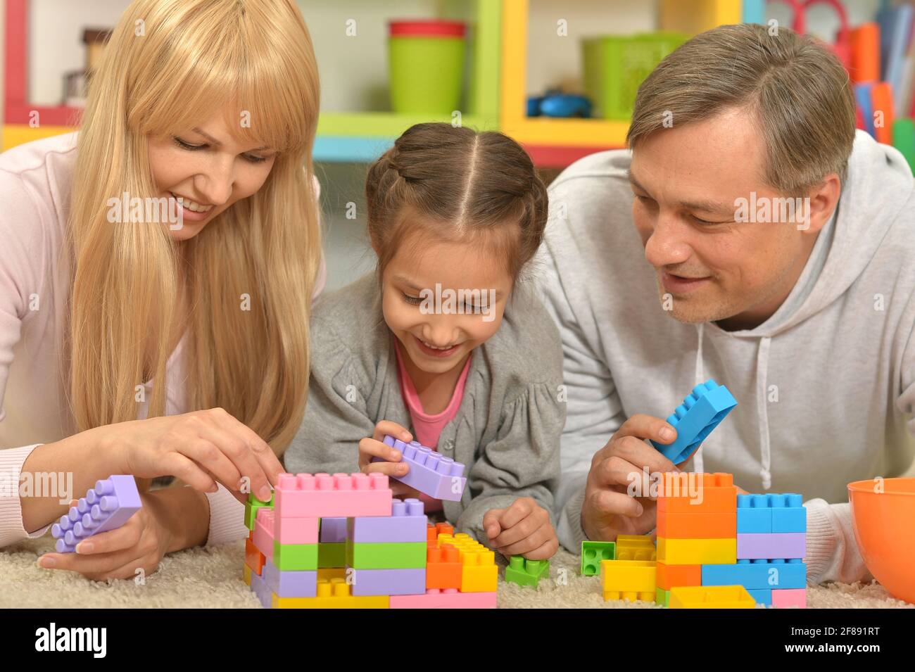 Happy family with children playing with toy blocks Stock Photo - Alamy