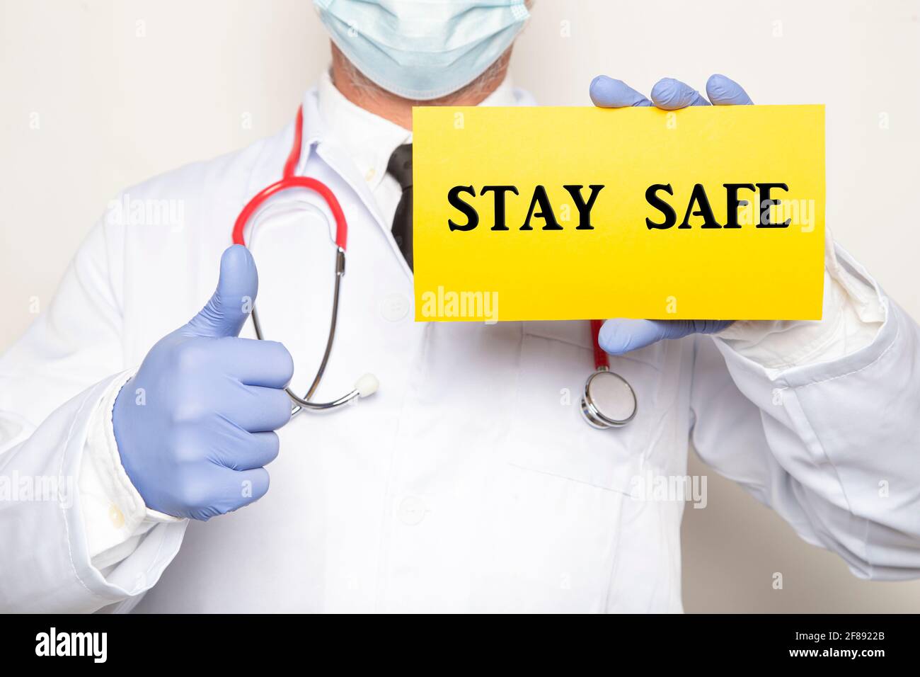 doctor raising thumb in sign of approval holding sign with text stay ...