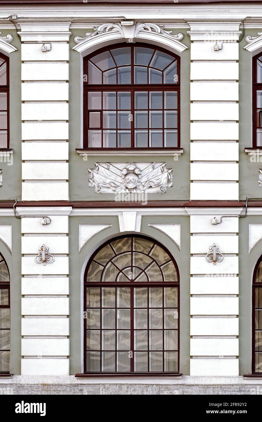 Two rectangular arched windows with a brown frame against a gray wall ...