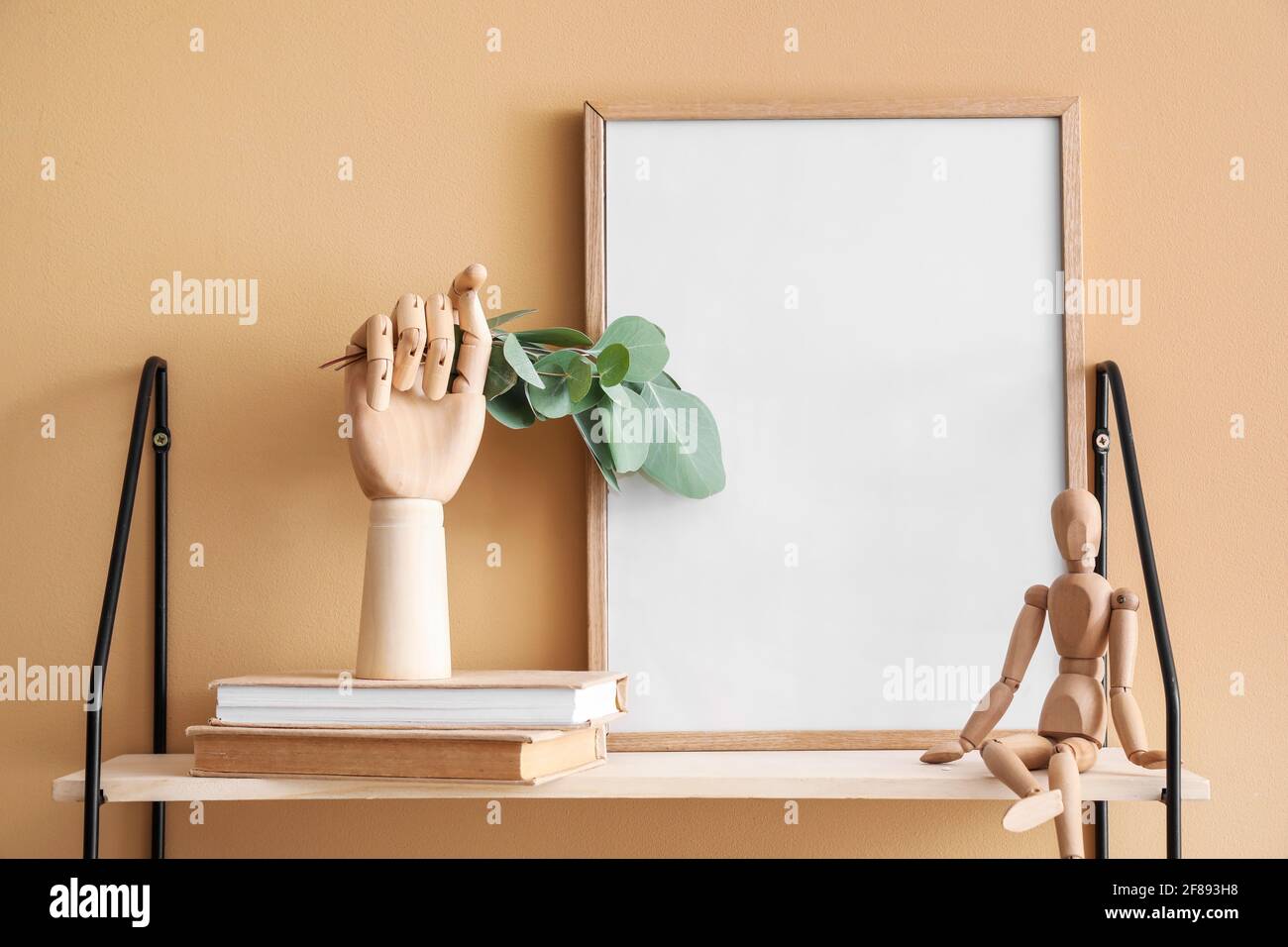 Wooden hand with books on shelf in room Stock Photo - Alamy