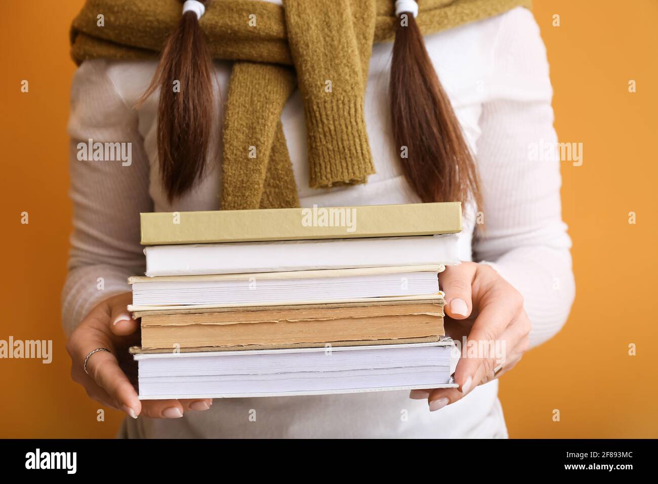 Woman with stack of books on color background, closeup Stock Photo - Alamy