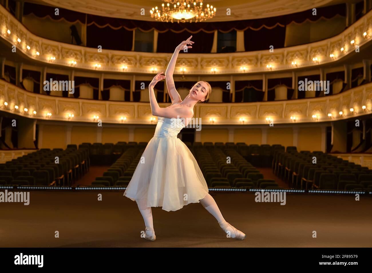 Beautiful young ballerina dancing in theatre Stock Photo - Alamy