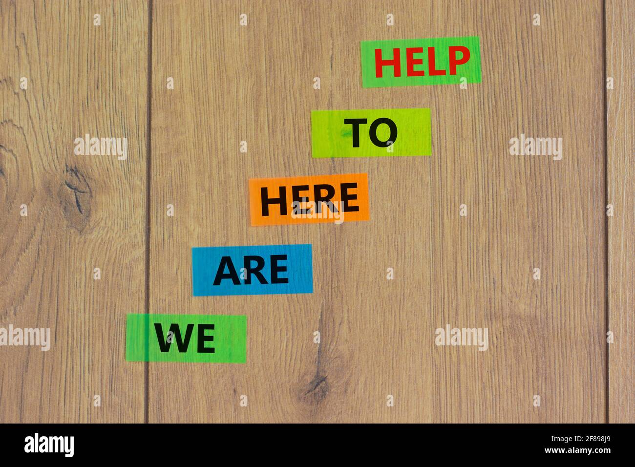 Support symbol. Color papers with words 'we are here to help ...