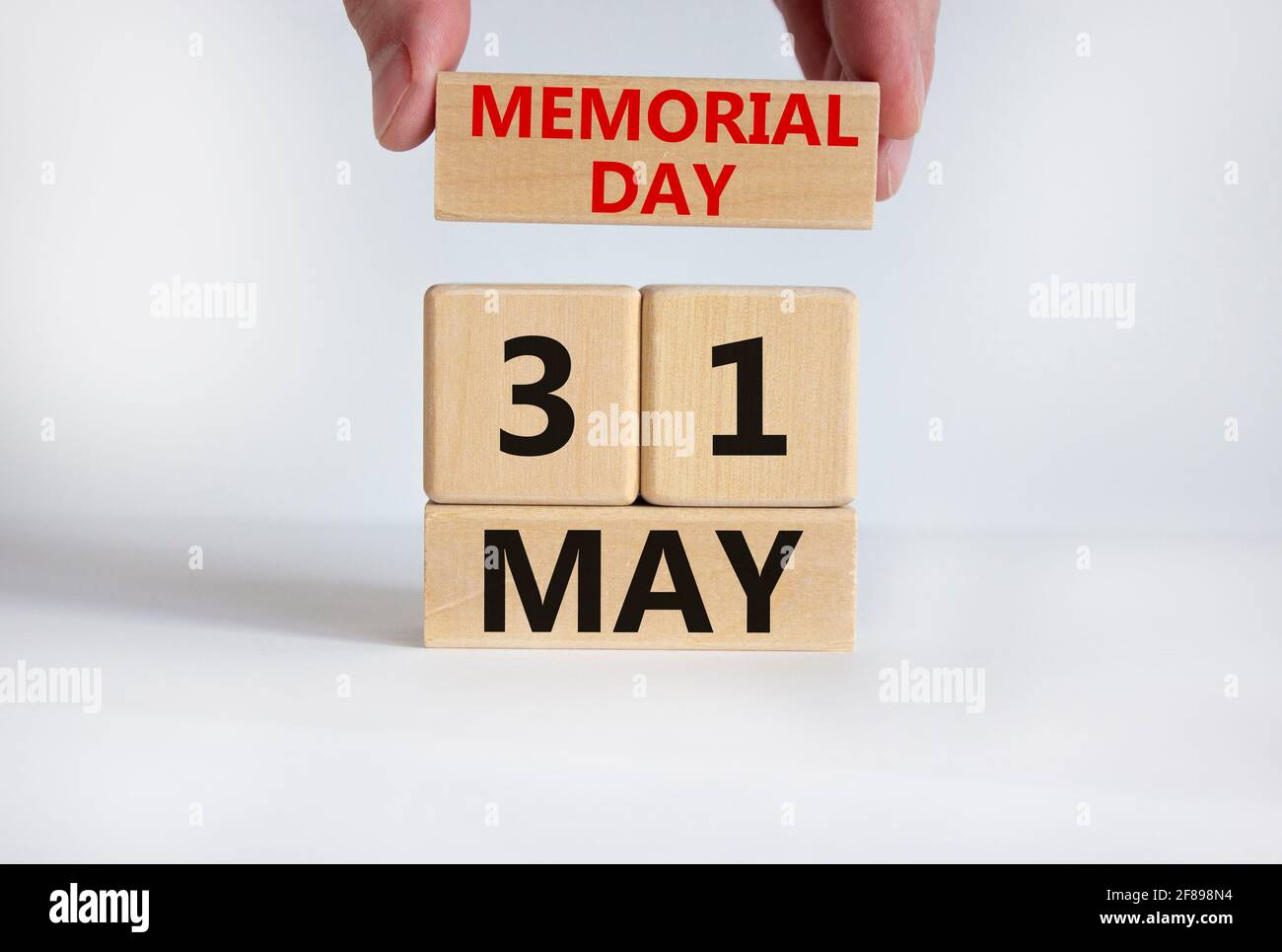 Memorial Day symbol. Male hand puts a block with the inscription ...