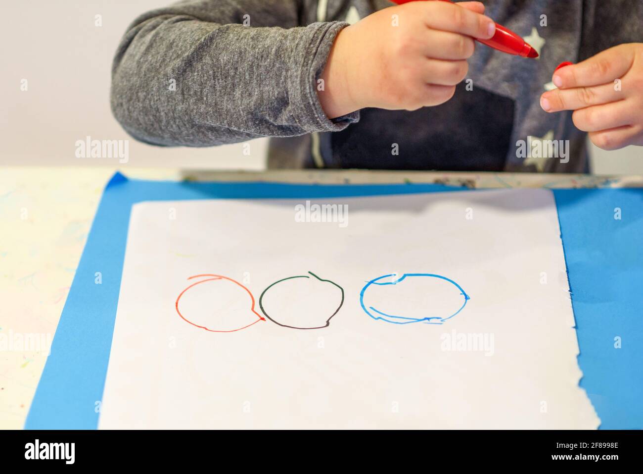 Little child develops fine motor skills, learns to draw circles. Close ...