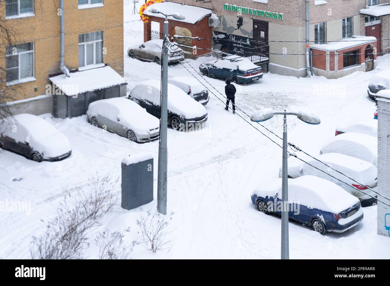 Overhead shot of a yard with cars fully covered with fresh thick ...