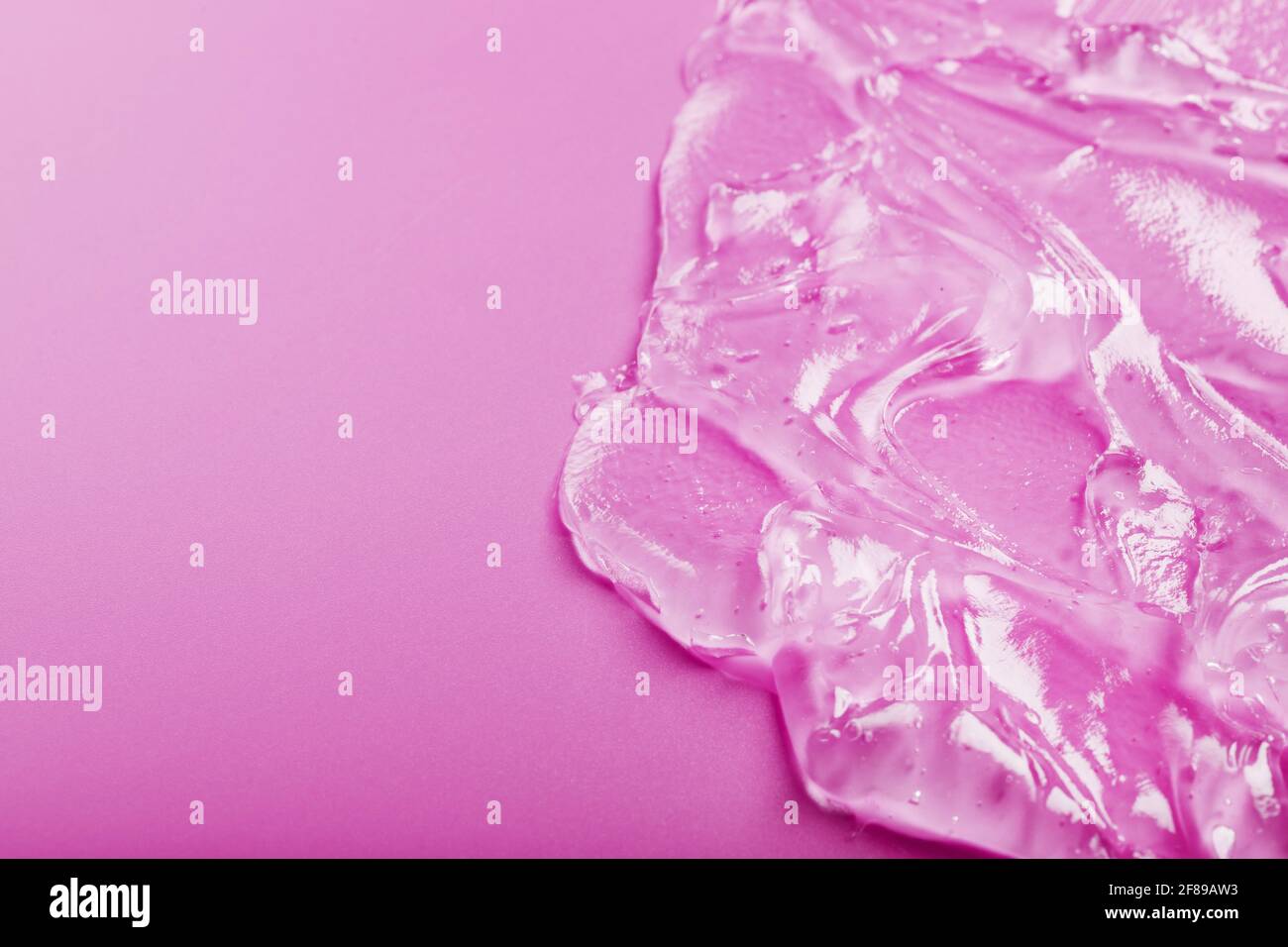 Transparent liquid gel on a pink background with free space. Antiseptic ...
