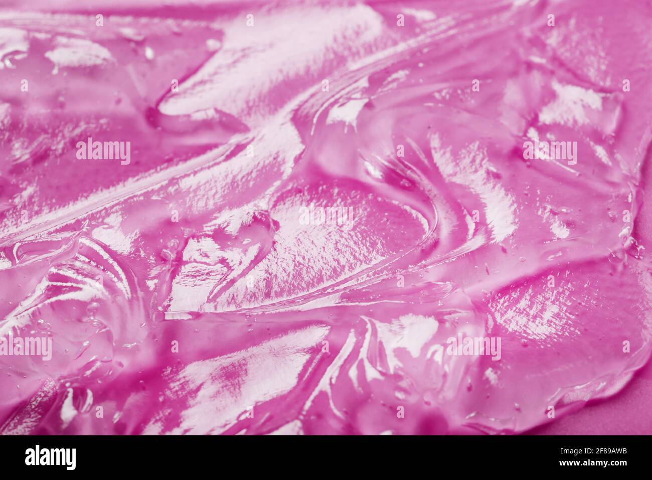 Transparent liquid gel on a pink background with free space. Antiseptic ...