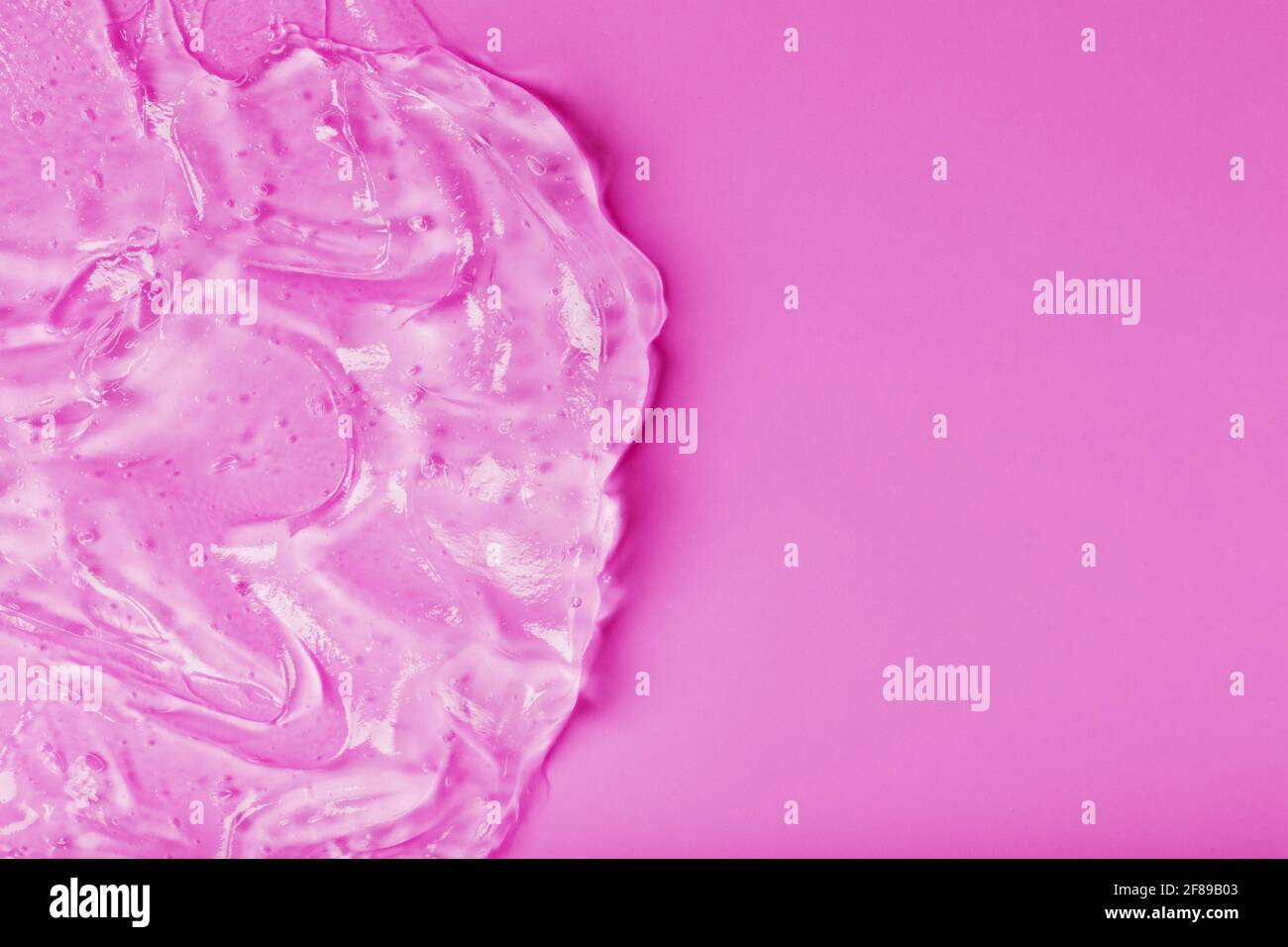Transparent liquid gel on a pink background with free space. Antiseptic ...