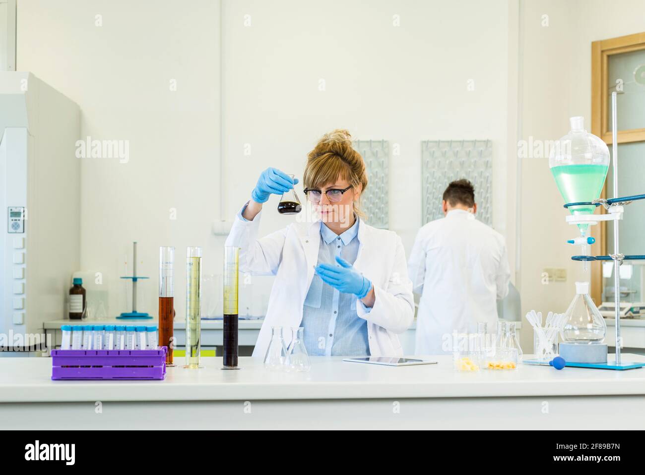 Female chemical scientist wearing glasses works with hemp CBD and CBDa ...