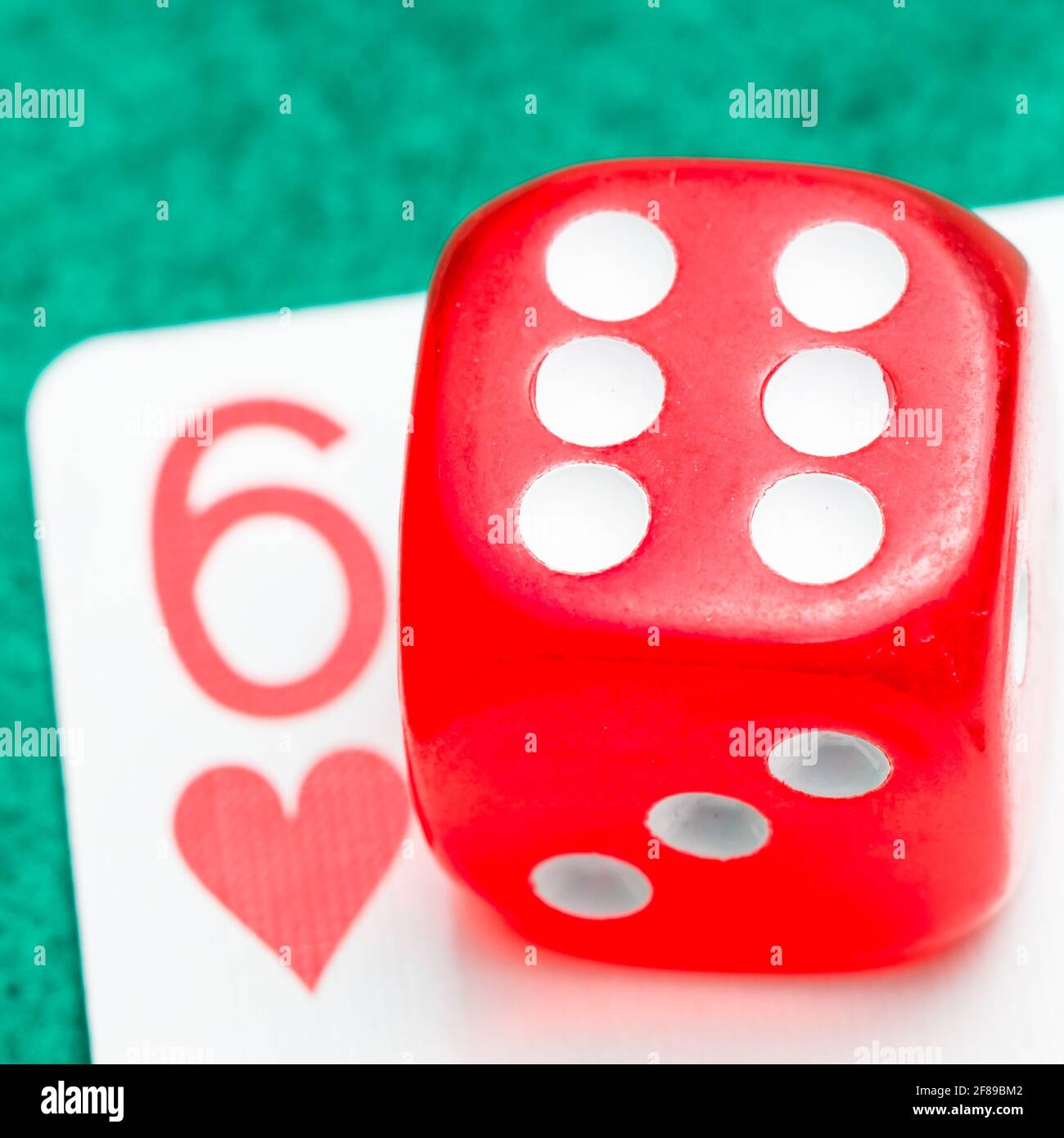 Vertical shot of red dice showing six on a six of hearts card Stock ...