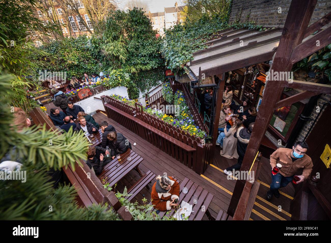 London, UK. 12 April 2021. Drinkers in the beer garden of the Faltering ...