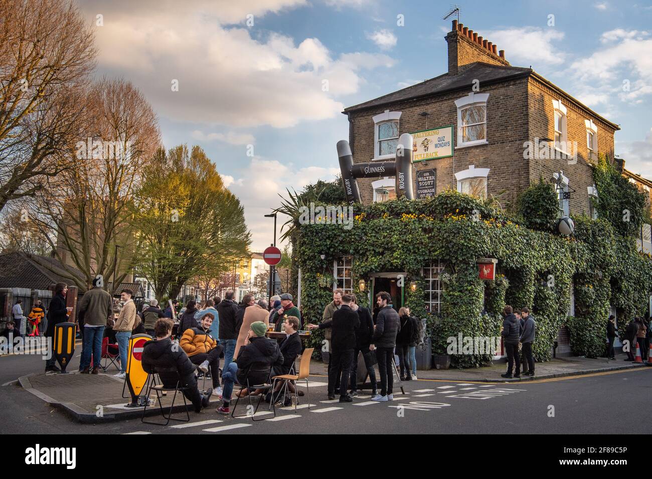 London, UK. 12 April 2021. Drinkers outside the Faltering Fullback pub ...