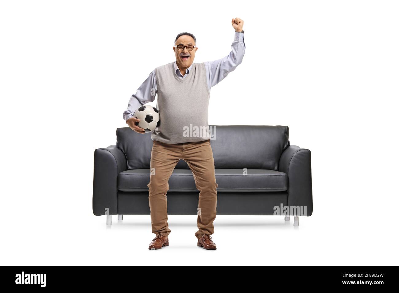 Mature man football fan cheering with a ball in front of a black ...