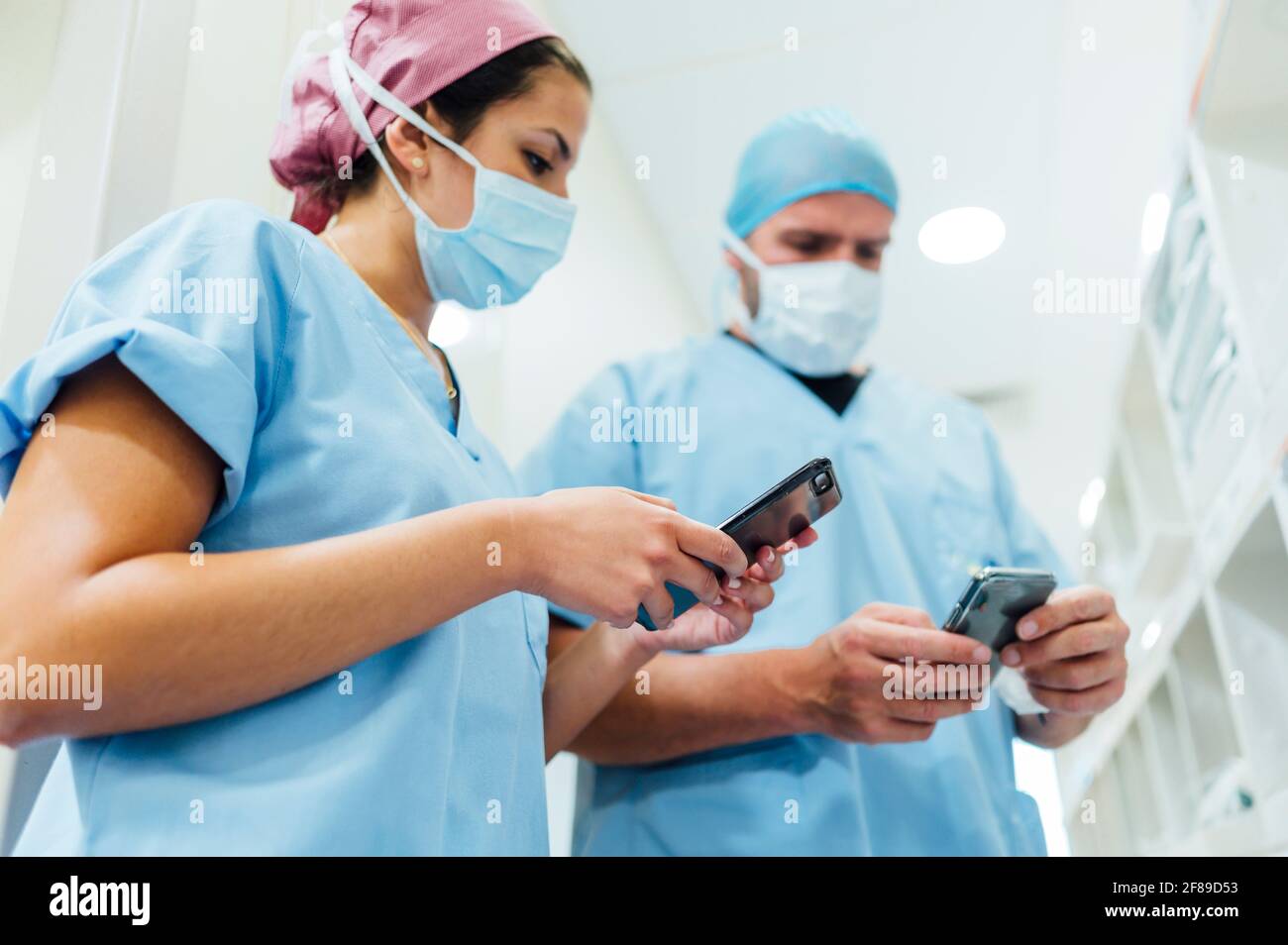 Doctors using cell phones in the hospital corridor. Medical concept ...