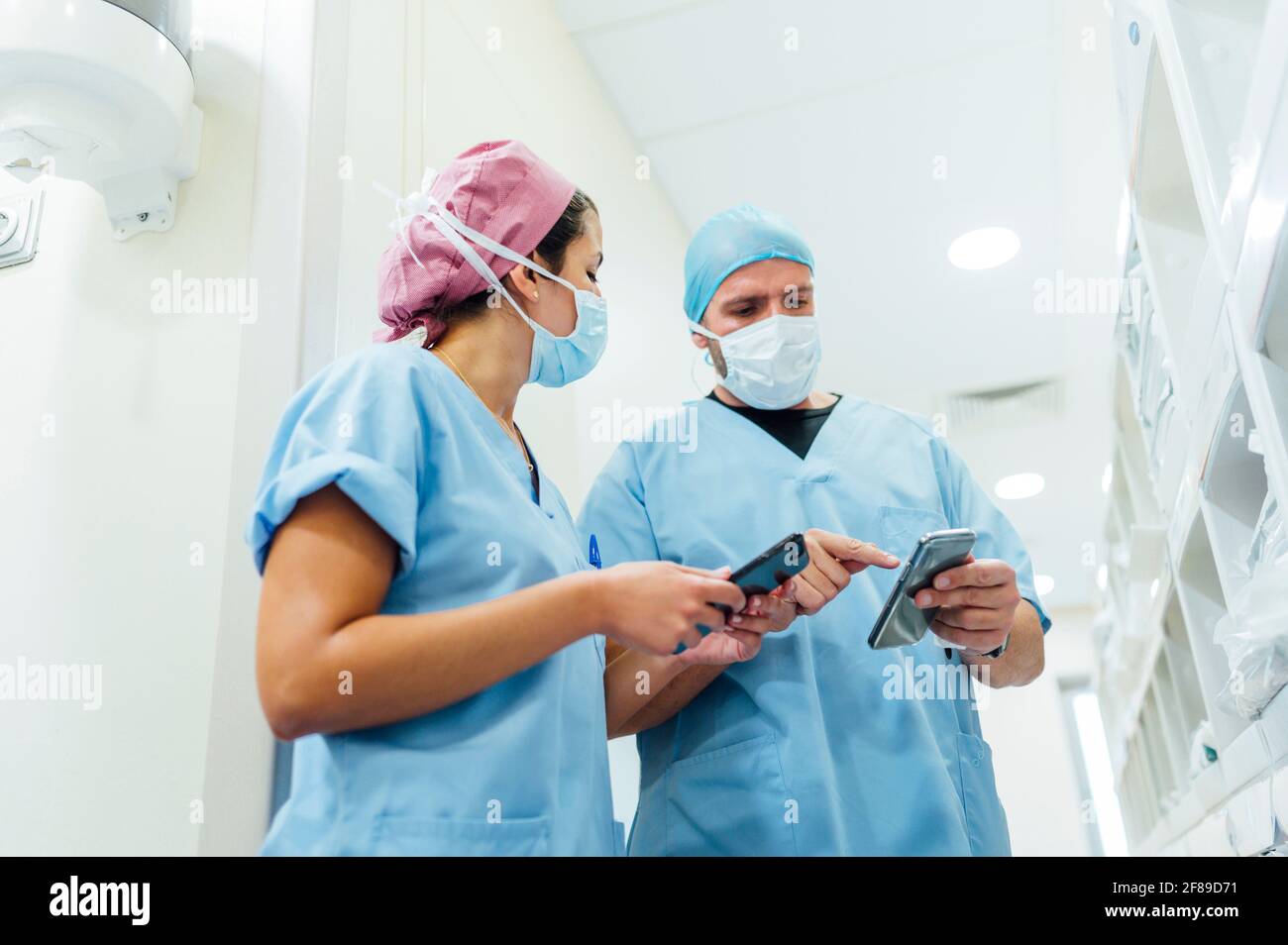 Doctors using cell phones in the hospital corridor. Medical concept ...