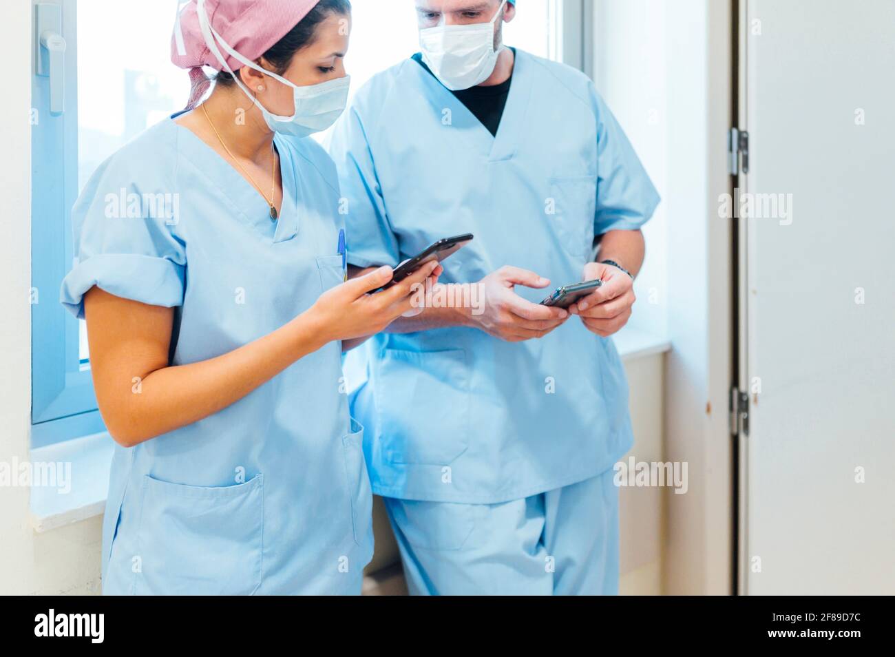 Doctors using cell phones in the hospital corridor. Medical concept ...