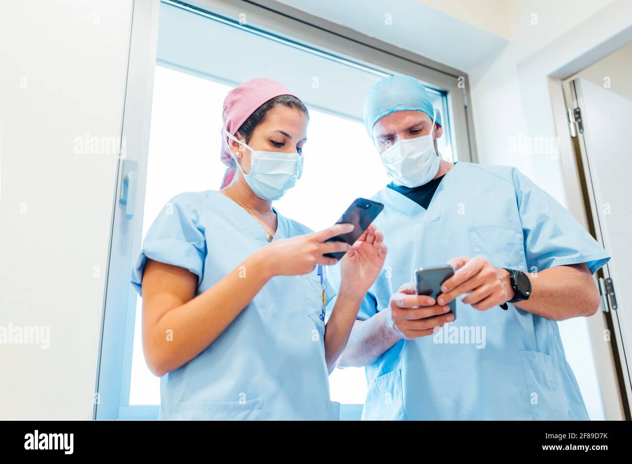 Doctors using cell phones in the hospital corridor. Medical concept ...