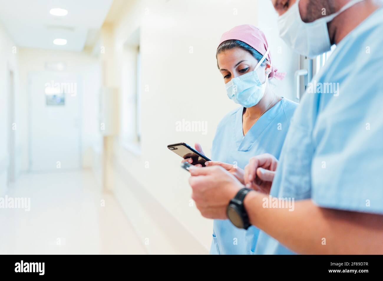 Doctors using cell phones in the hospital corridor. Medical concept ...