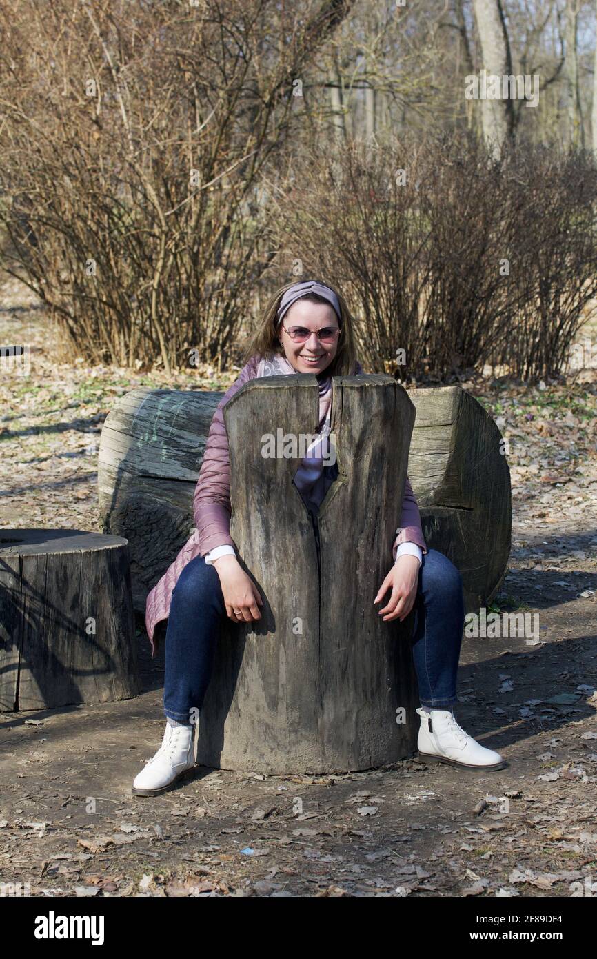 Girl on a walk in the spring park. Sits on a park bench Stock Photo - Alamy