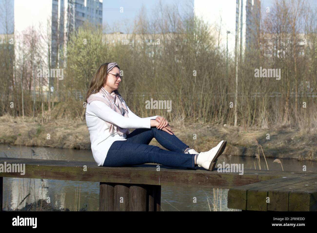 Girl on a walk in the spring park. Sits on a park bench Stock Photo - Alamy