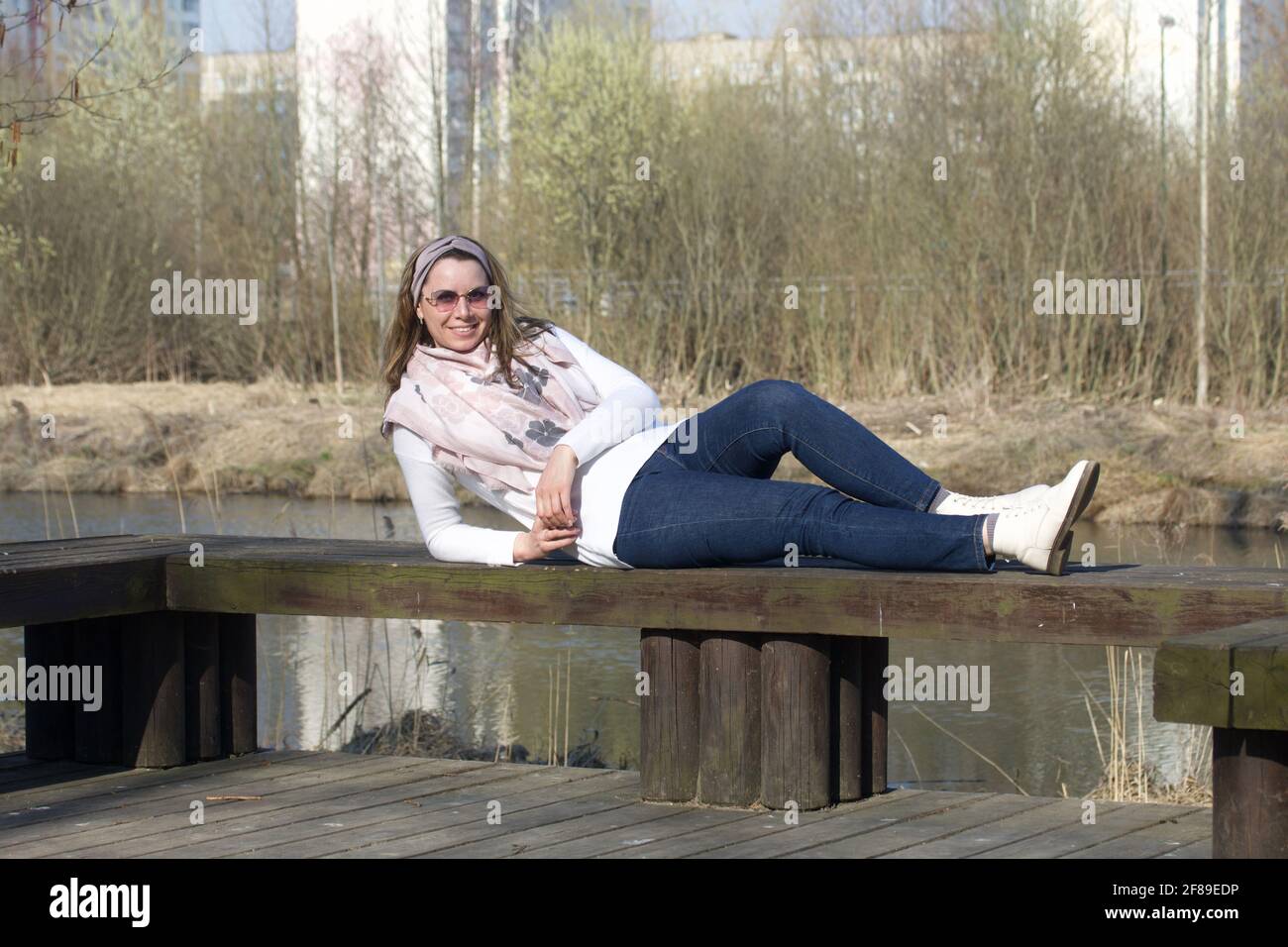 Girl on a walk in the spring park. Sits on a park bench Stock Photo - Alamy