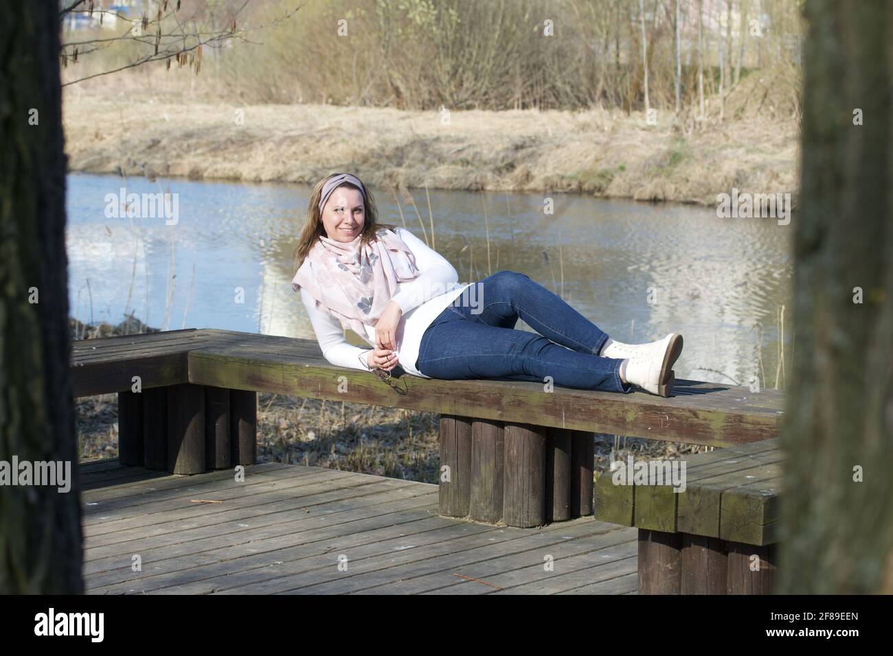 Girl on a walk in the spring park. Sits on a park bench Stock Photo - Alamy